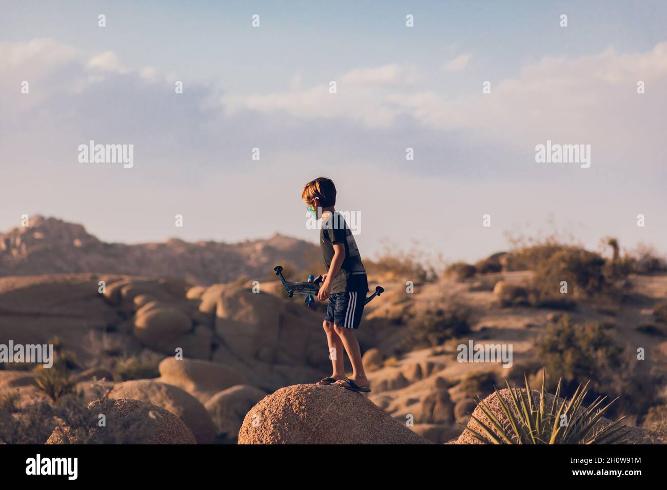 Boy playing with bow and arrow in the desert Stock Photo - Alamy