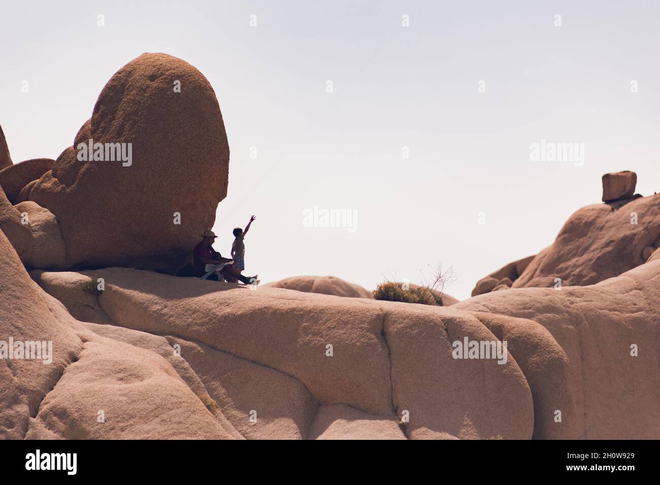 Family playing on big rocks in the desert Stock Photo - Alamy