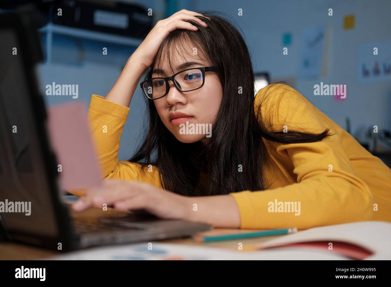 Stressed exhausted woman sitting at office desk and working overtime ...