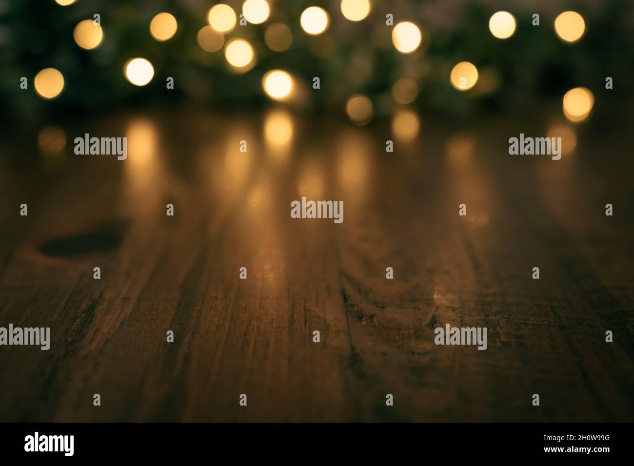 Border of defocused christmas lights and green branches on a dark wood ...
