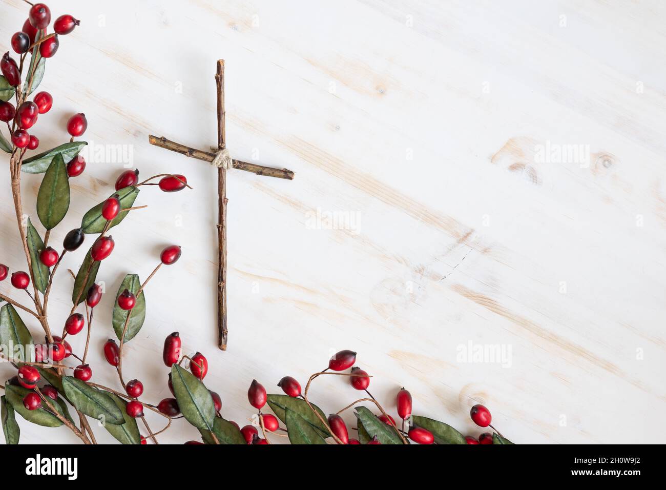 simple wood cross with christmas holly berry border on white wood ...