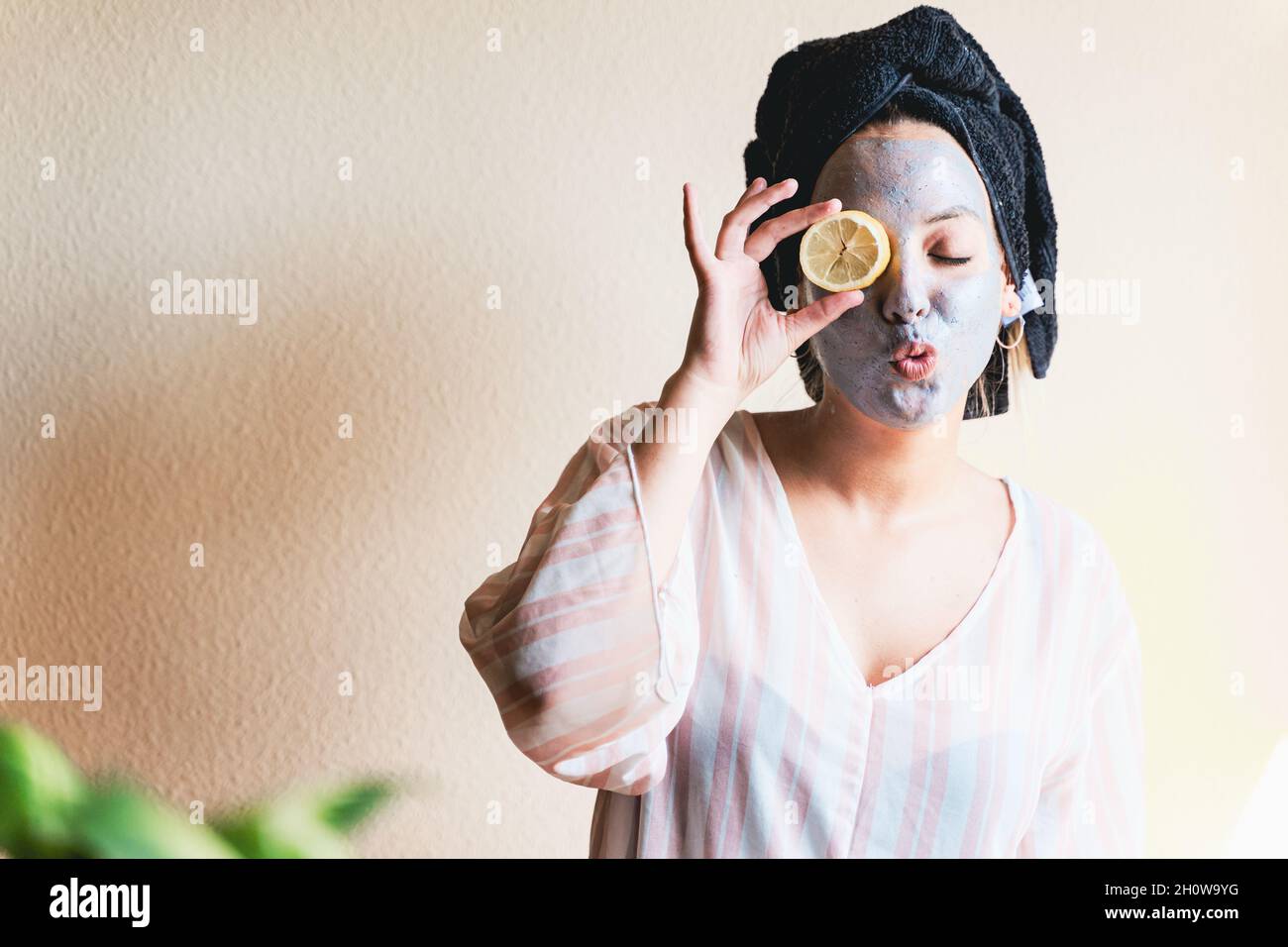 Happy girl applying a facial cleansing mask while Stock Photo - Alamy