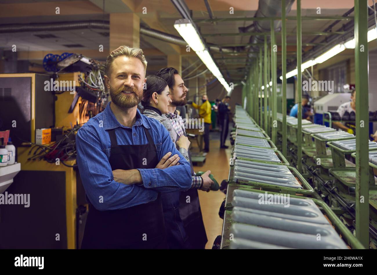Happy male worker standing in shoe manufacturing workshop at footwear ...