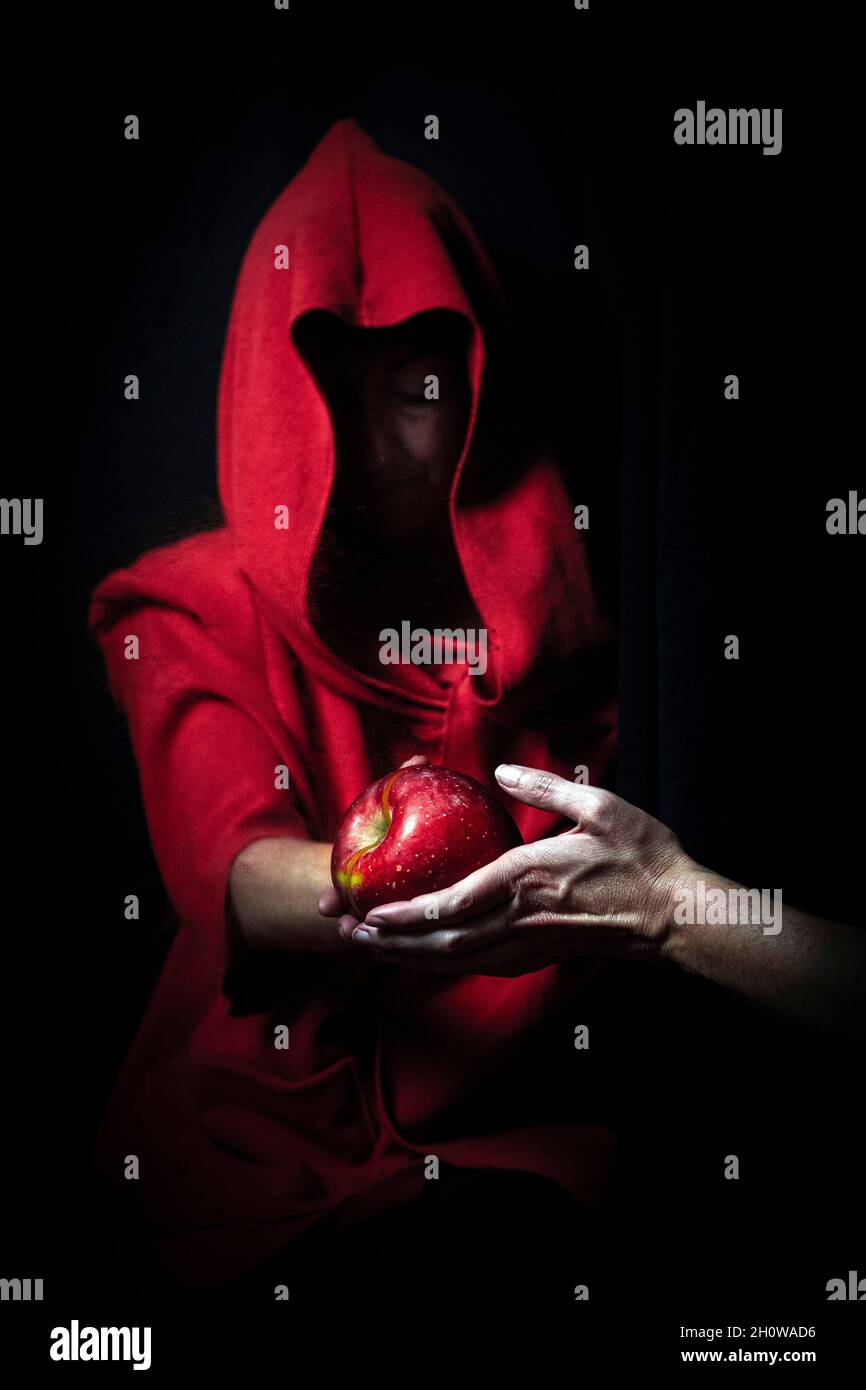 woman handing half red apple, mirror reflection Stock Photo - Alamy