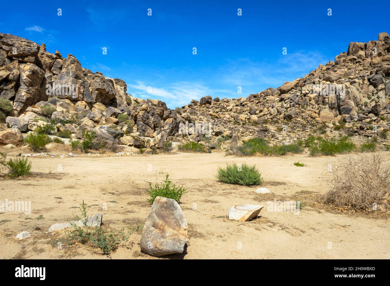 A valley in the Mojave Desert with a rock formation on a hill Stock ...
