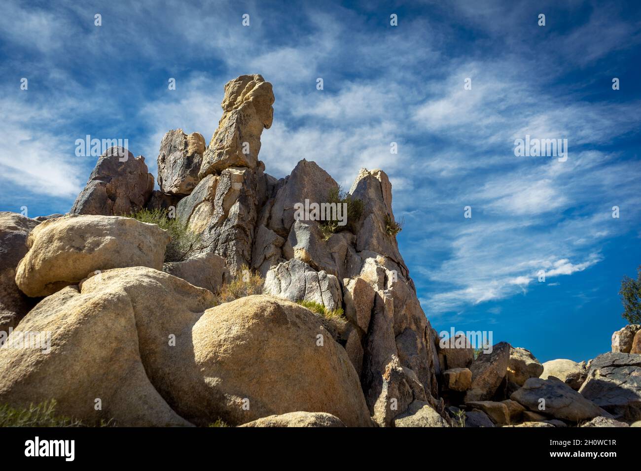 Towering rock formation with a cloud sky in the California Mojave ...