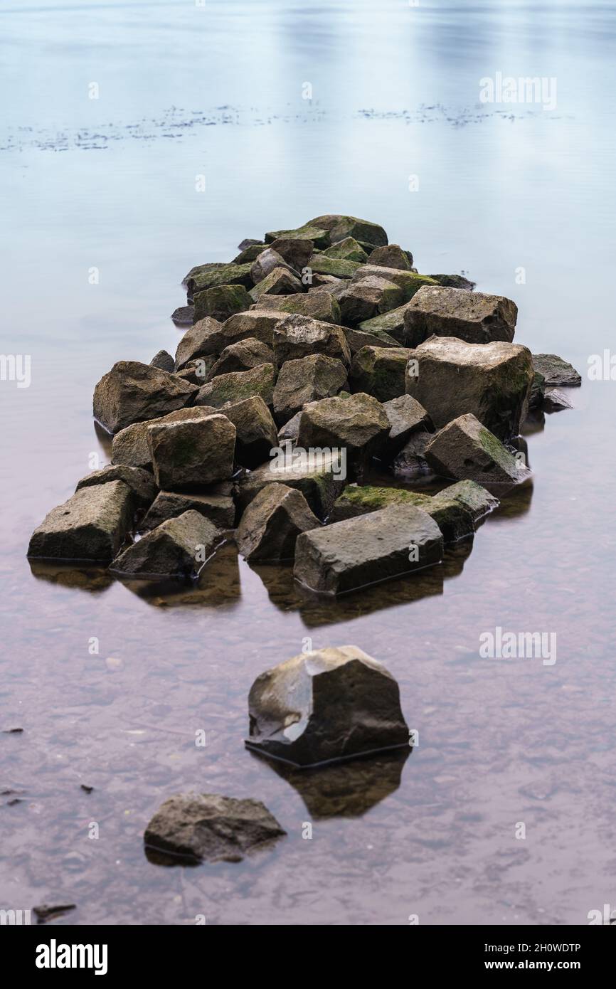 Pile of heavy basalt blocks in the water of a dutch river Stock Photo ...