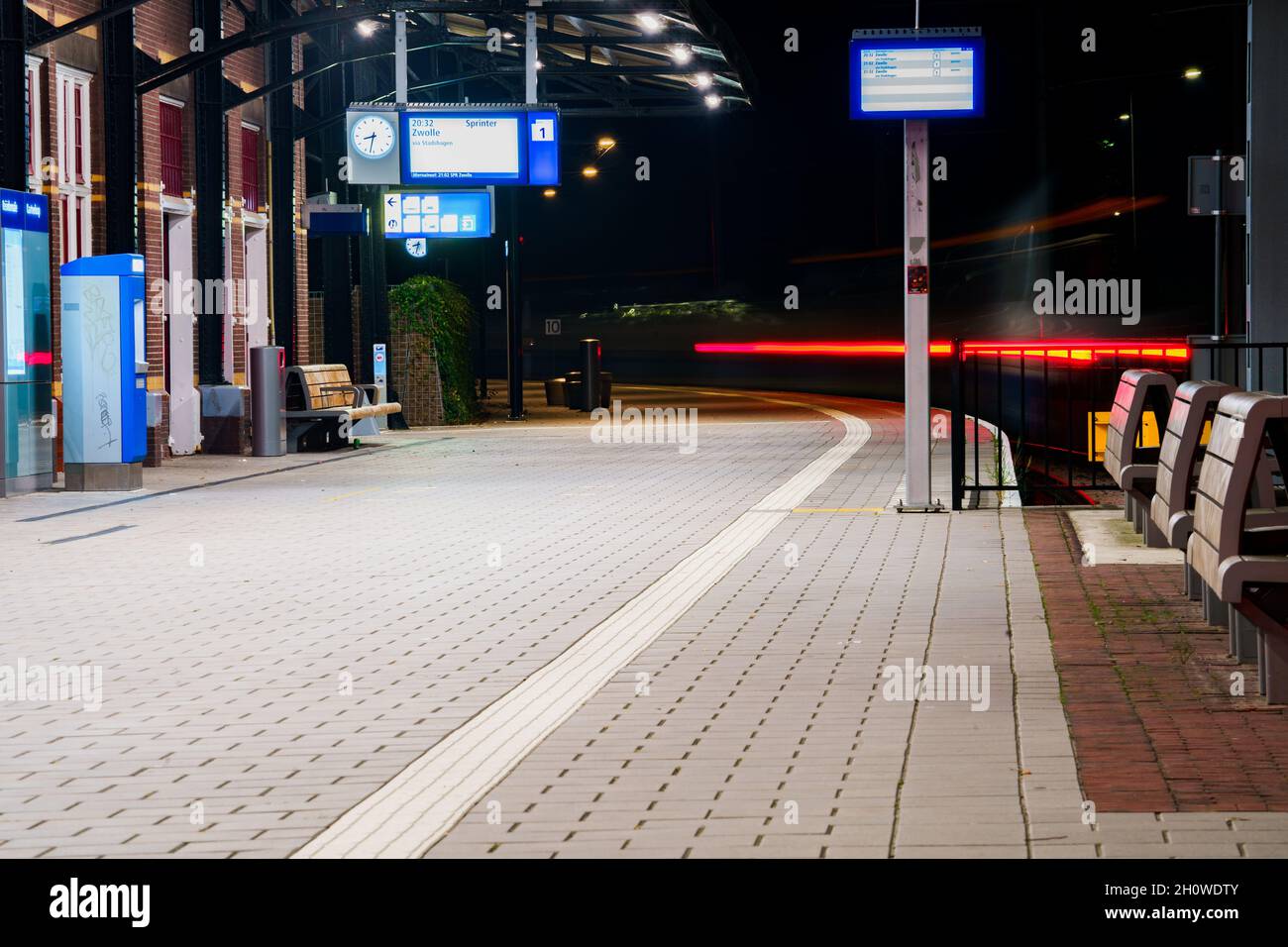 Light trail of the local train in the railway station at the night ...