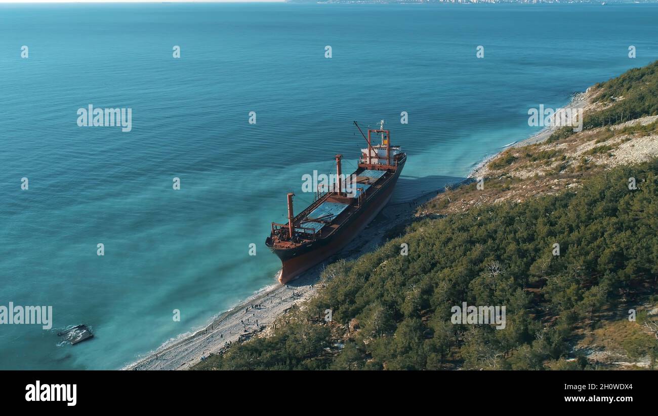 Aerial view of large cargo ship in still blue water near coastline. Sea ...