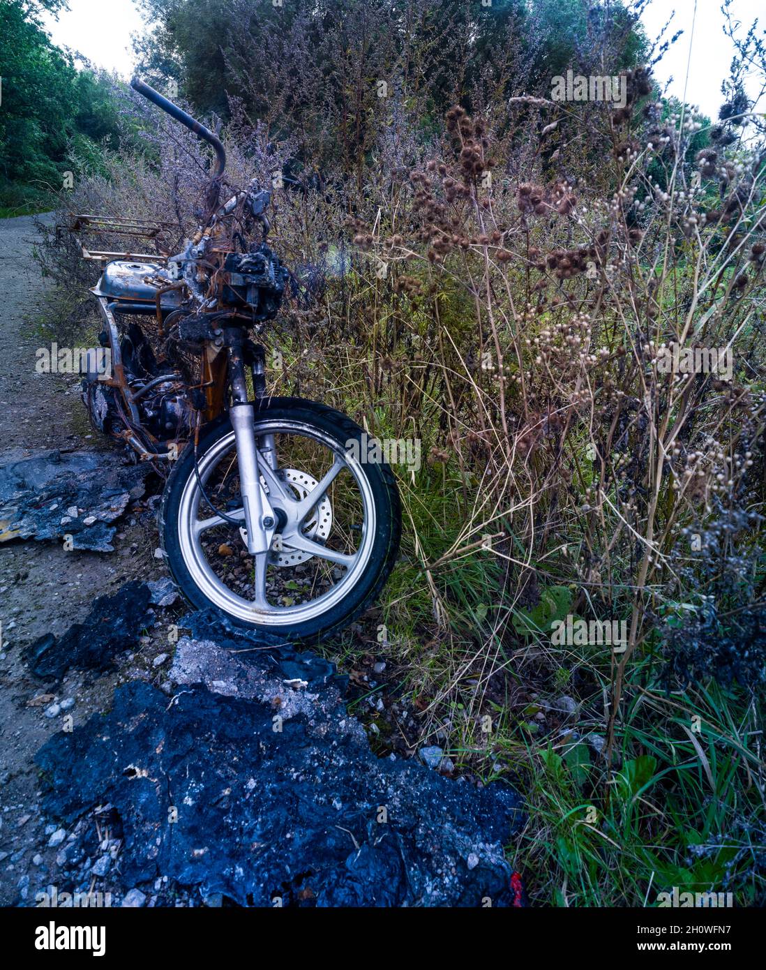 Burned out bike dumped onto recreational land, environmental pollution ...