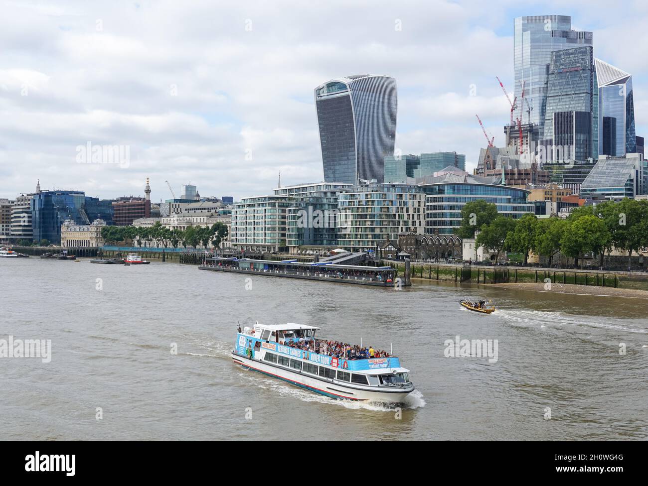 Cruise boat on the River Thames passing the City of London, England ...