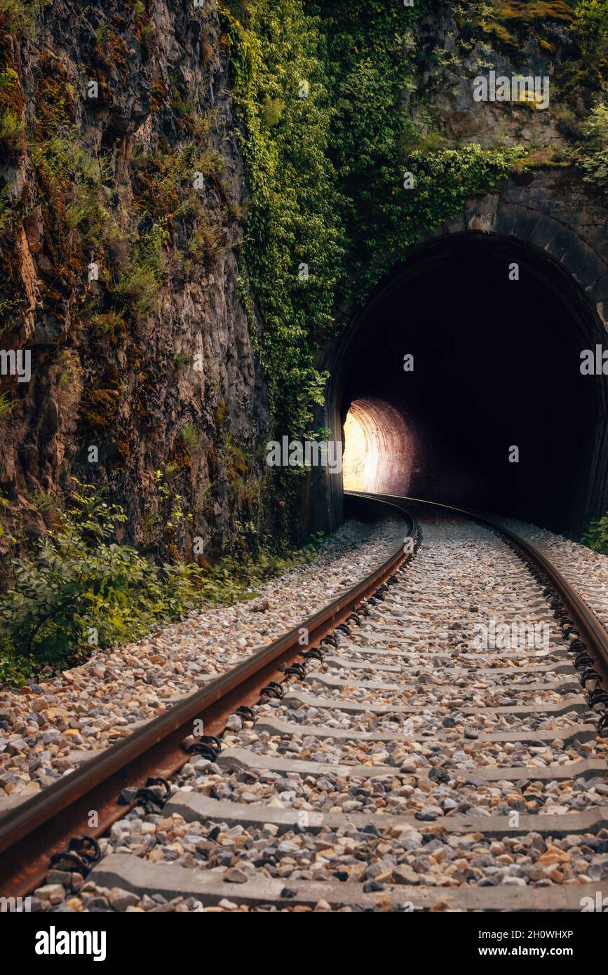 Vertical shot of train tracks and a tunnel surrounded by cliffs Stock ...