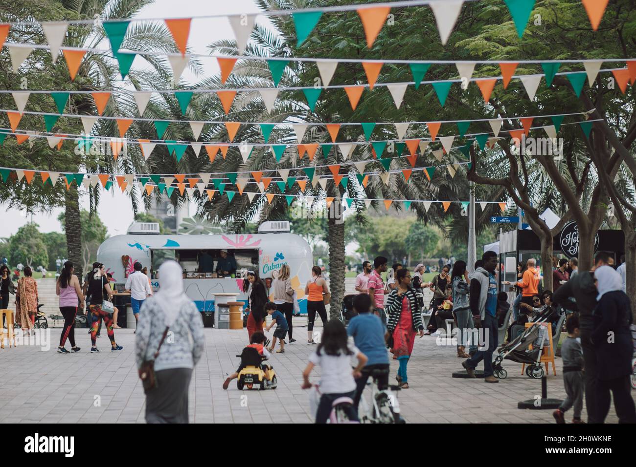 People walking at the park. Kids play and adults go around in the fair ...