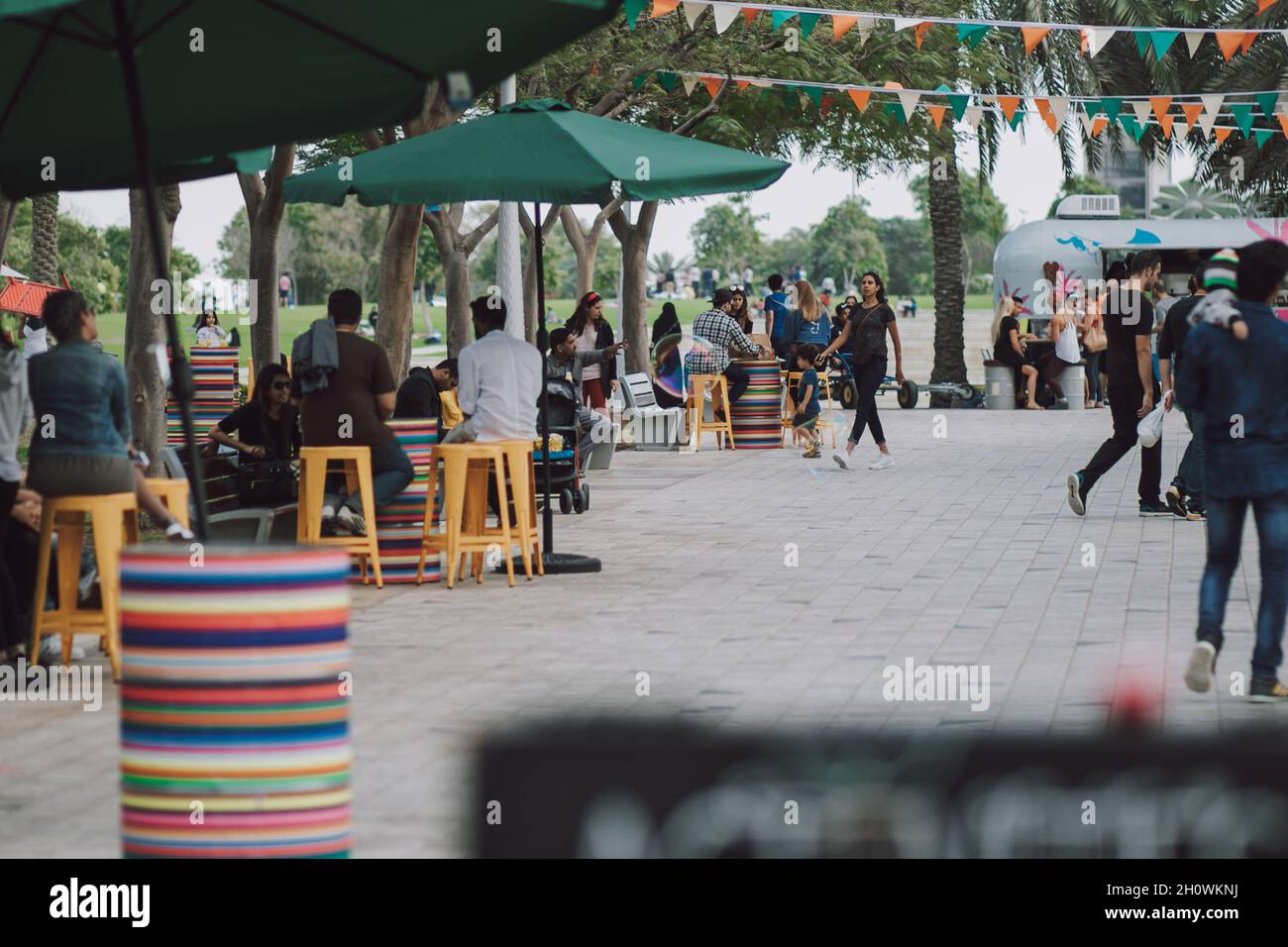 People walking at the park. Kids play and adults go around in the fair ...