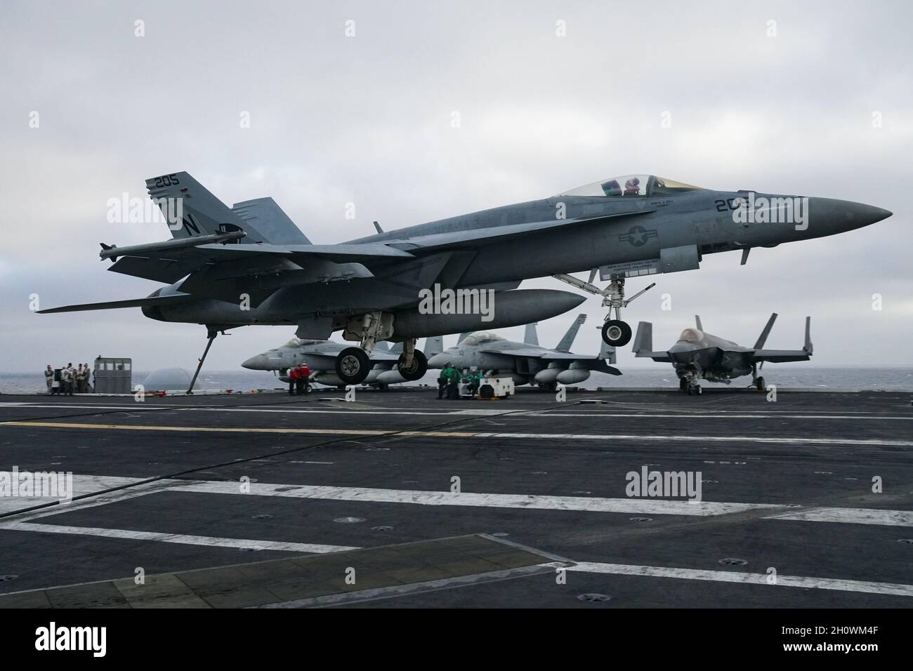 Naval flight operations take place aboard a aircraft carrier featuring ...