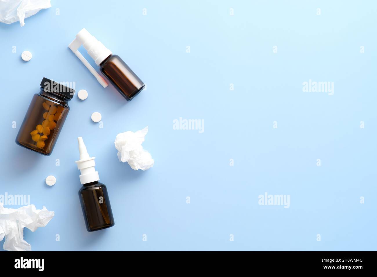 Flat lay composition with pills, nasal drops, cough spray on blue ...