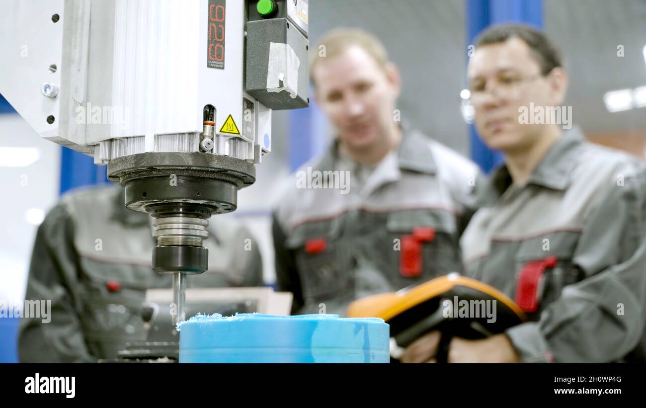 Automotized engraving mechanism. Scene. Workers monitor process of ...