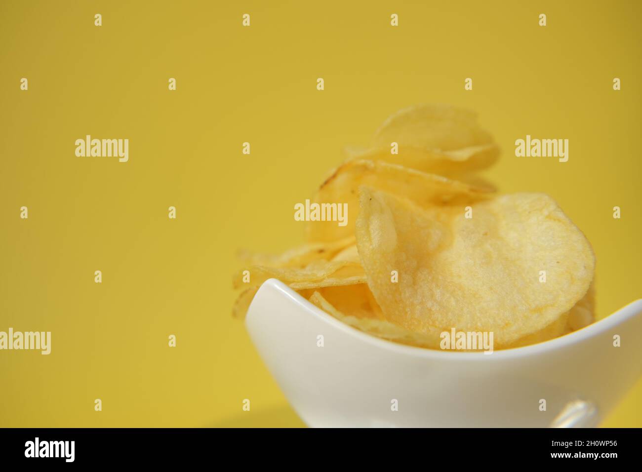 Potato chips. Chipsy. chips close-up in ceramic cup on yellow ...