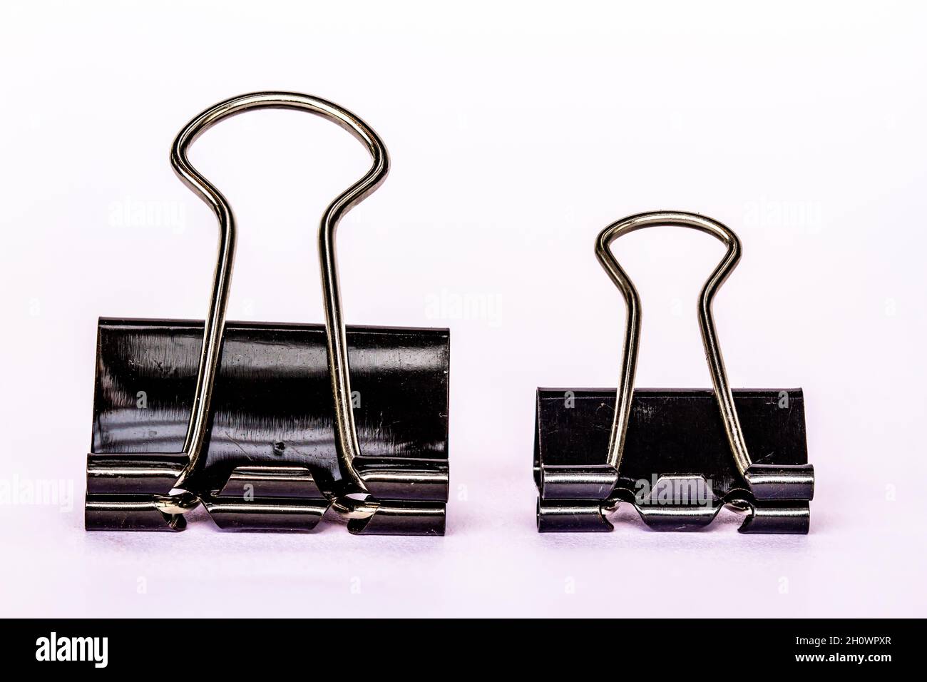 Two black metal paper clips, isolated with a white background, for ...