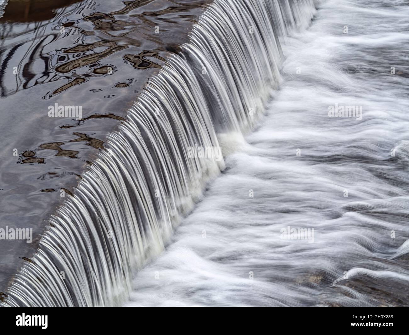 A small flat cascade in a calm river. Water background Stock Photo - Alamy
