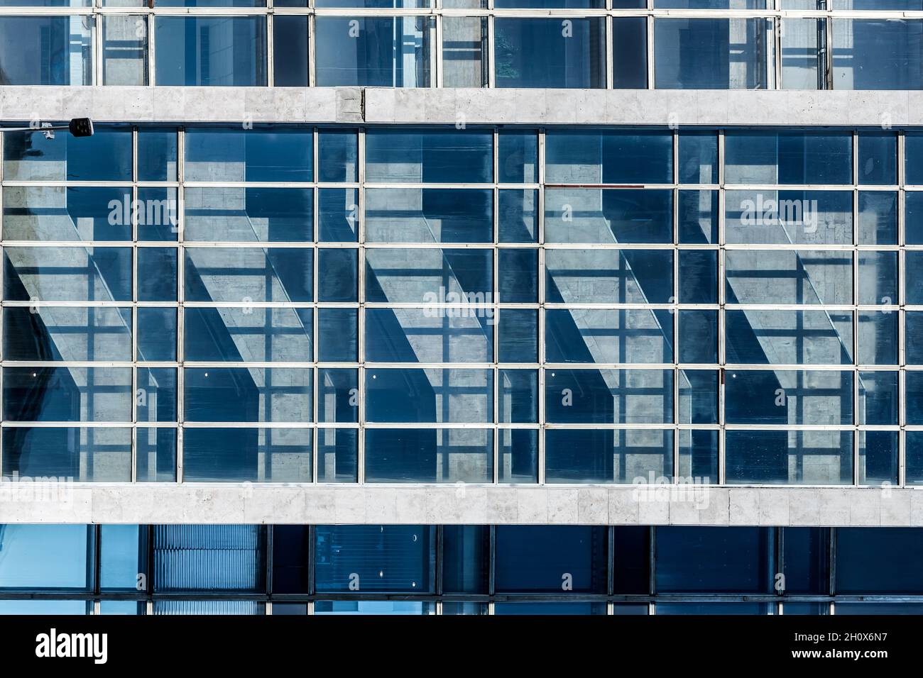 high-tech office building with transparent walls reflecting a bright ...