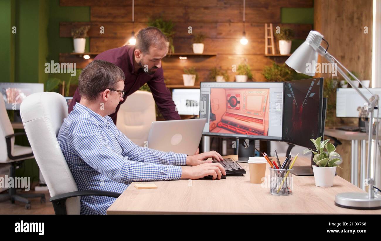 Graphic designer in game industry sitting at his office discussing ...