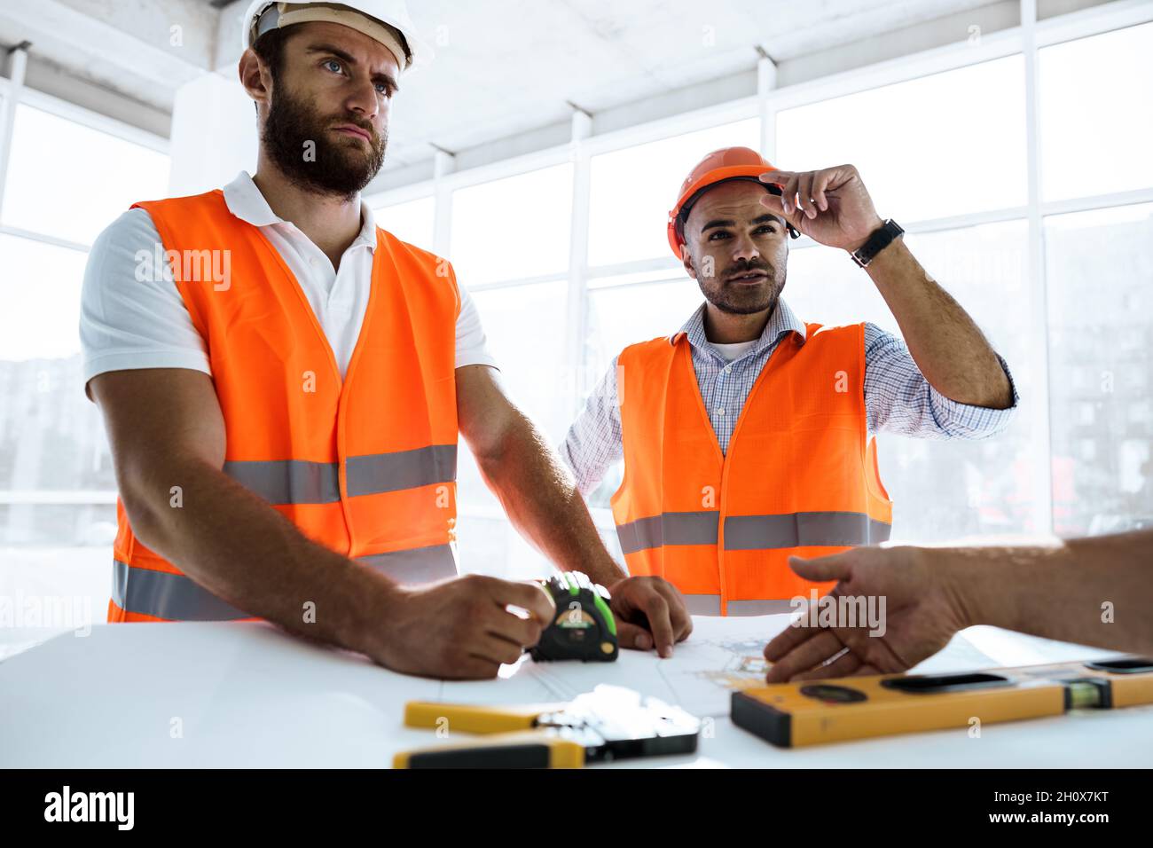 Two engineers man looking at project plan on the table in construction ...