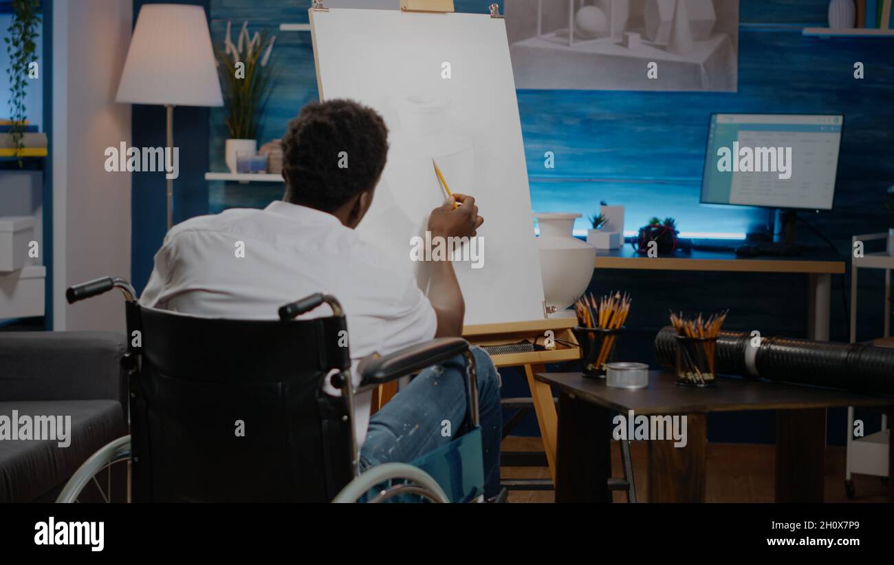 Disabled african american artist working on drawing with pencil on ...