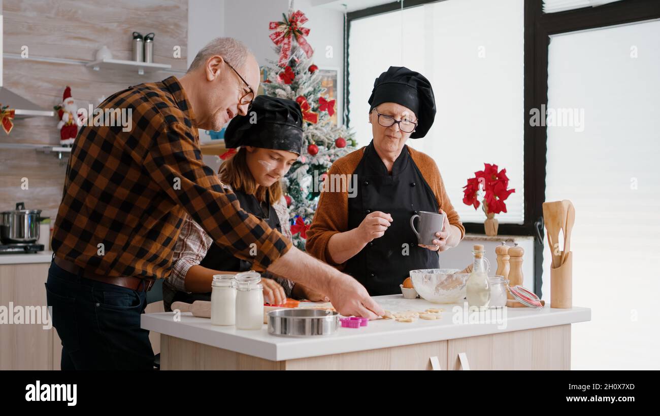 Grandparents teaching granddaughter how to make xmas homemade ...