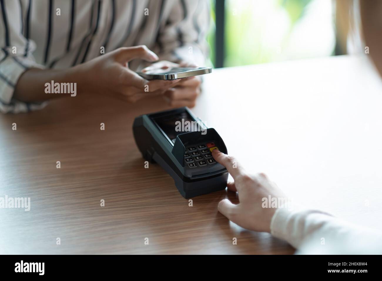 Close up customer make mobile payment contactless paying with NFC ...