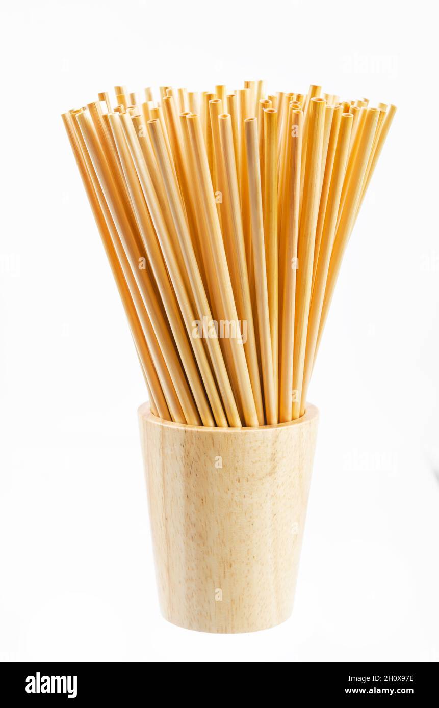 Wheat straw for drinking water in wooden glass on white background ...