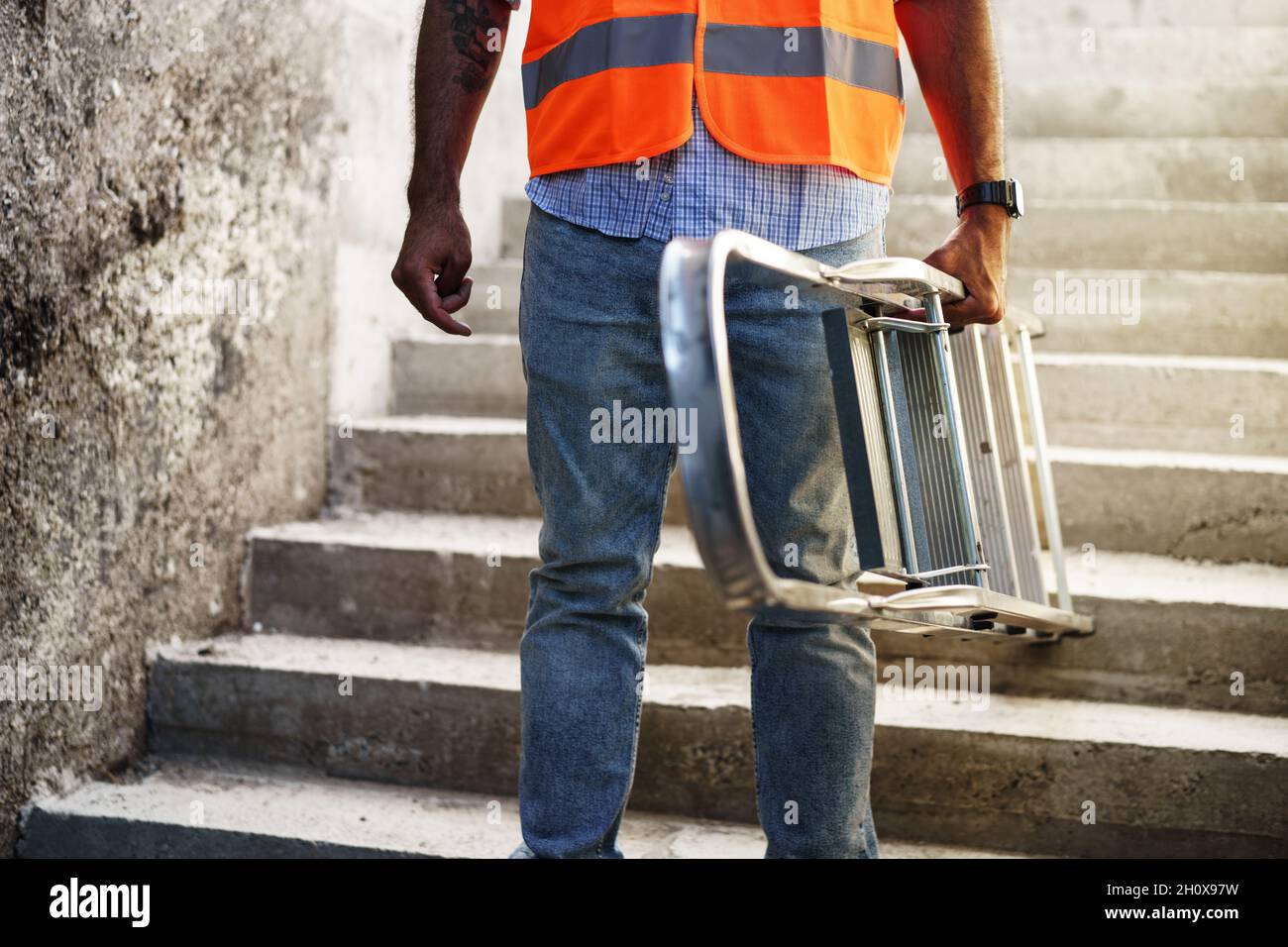 Professional builder carrying metal ladder, close up Stock Photo - Alamy