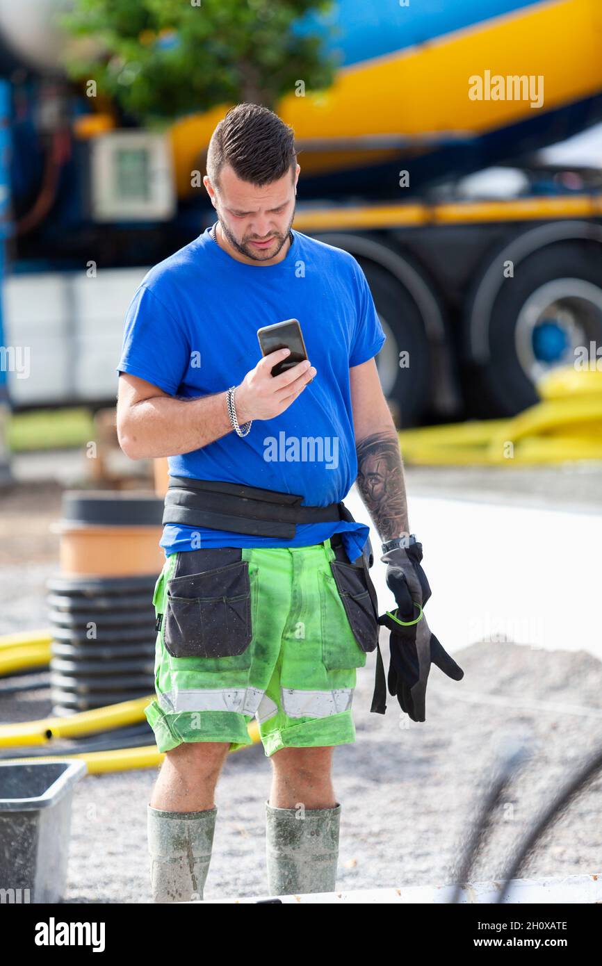 Construction worker looking at phone hi-res stock photography and ...