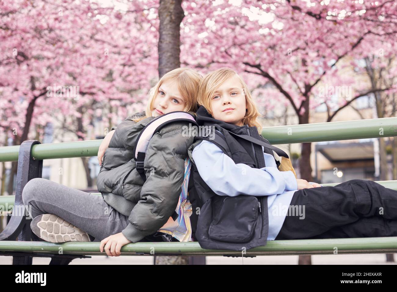 Girls sitting on bench Stock Photo - Alamy