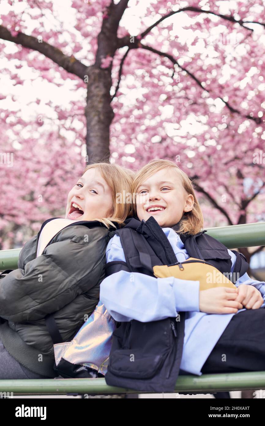 Girls sitting on bench Stock Photo - Alamy