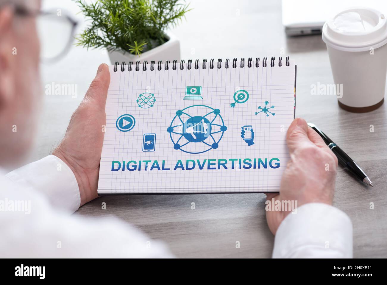 Hand holding a notepad with digital advertising concept Stock Photo - Alamy