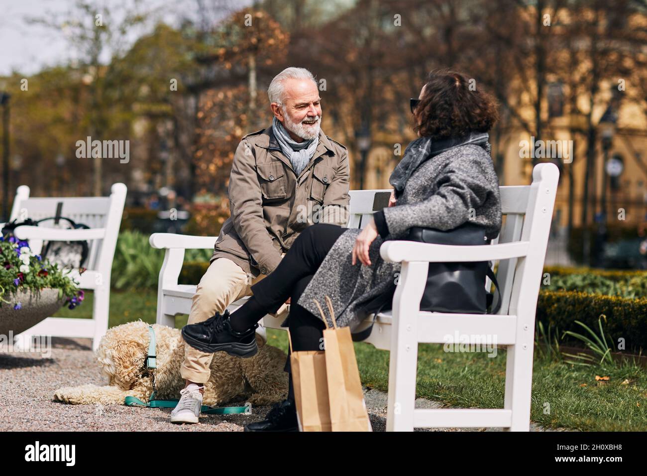 Couple talking on bench Stock Photo - Alamy