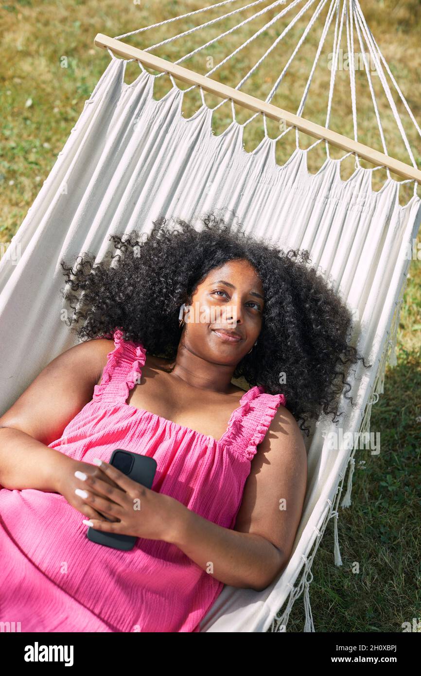 Woman relaxing on hammock Stock Photo - Alamy