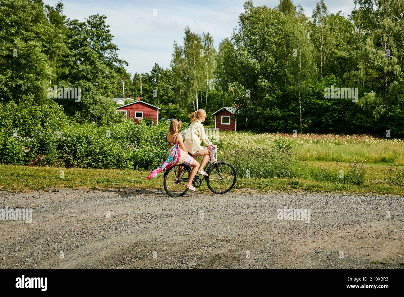 Two friends riding bicycle Stock Photo - Alamy