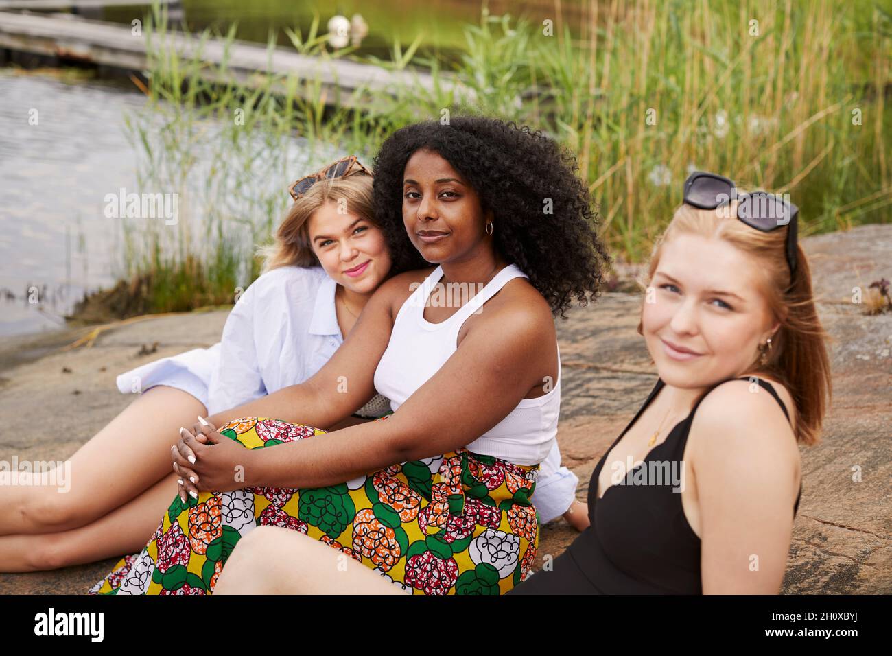 Group of friends resting at lakeside Stock Photo - Alamy