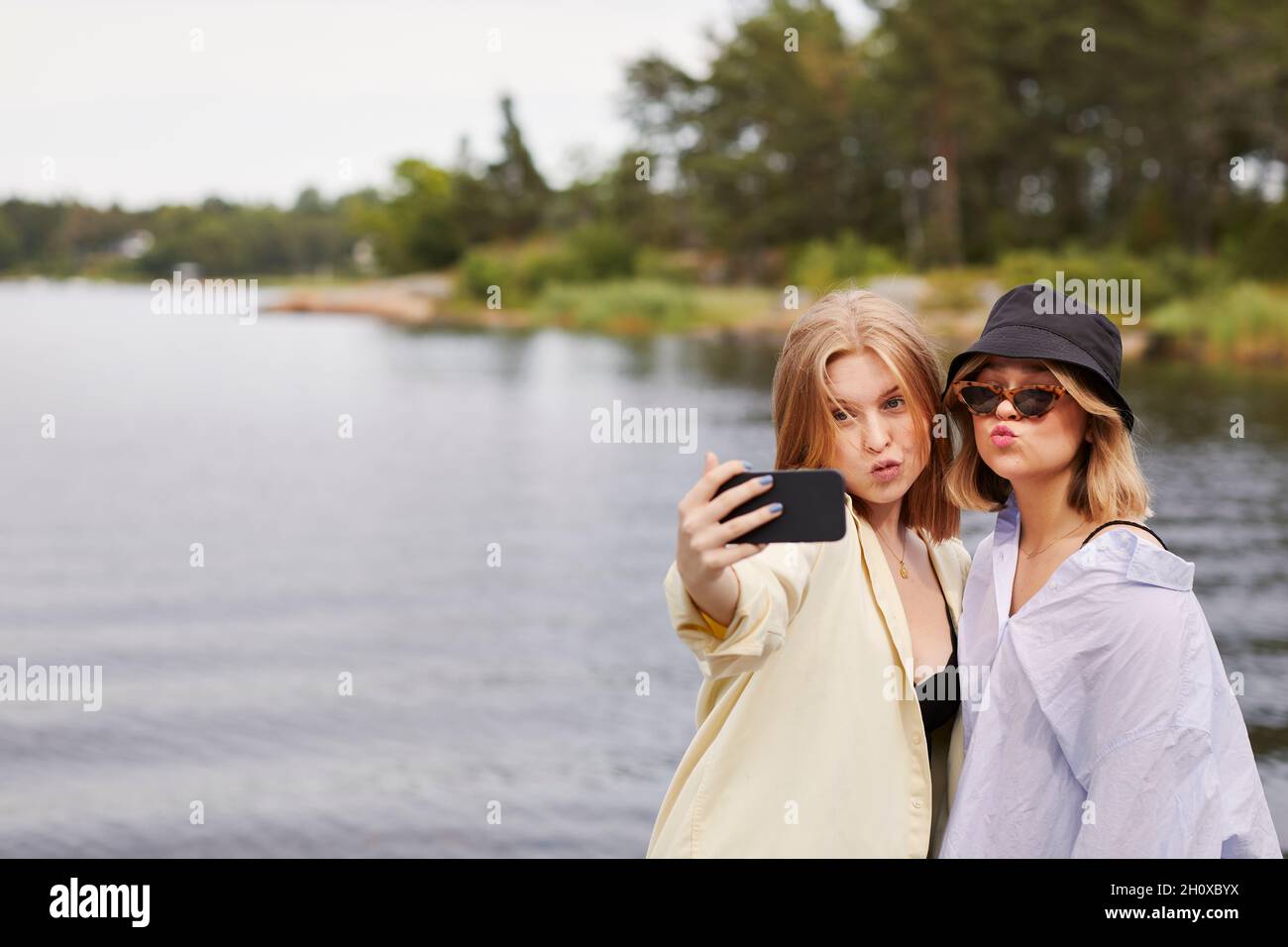 Two friends taking selfie at lakeside Stock Photo - Alamy