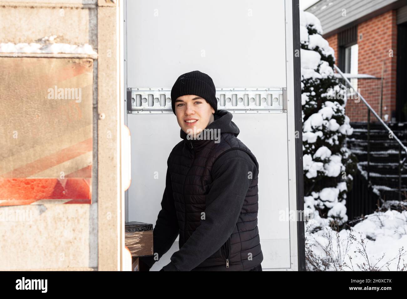 Man unloading parcels from car trunk Stock Photo - Alamy