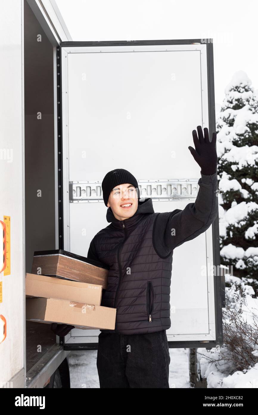 Man unloading parcels from car trunk Stock Photo - Alamy