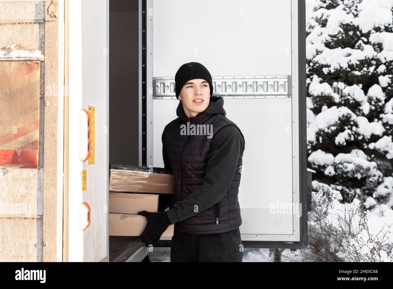 Man unloading parcels from car trunk Stock Photo - Alamy