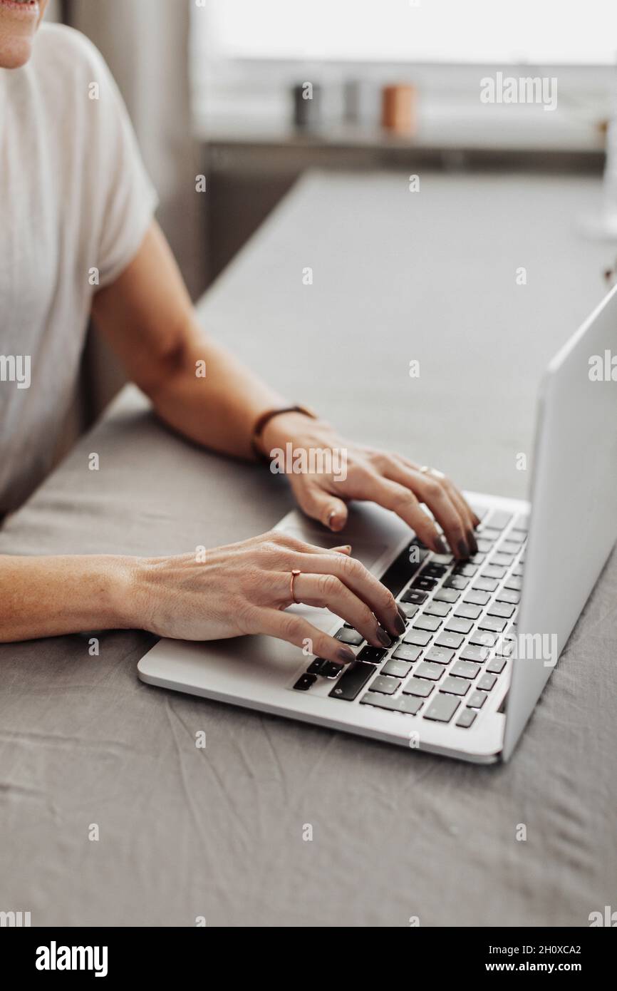 Woman's hand on laptop keyboard Stock Photo - Alamy