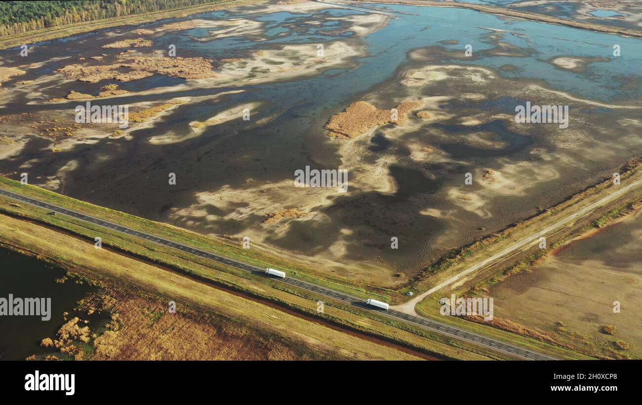 Aerial View Of Highway Road Through Ponds Autumn Landscape. Two Trucks ...