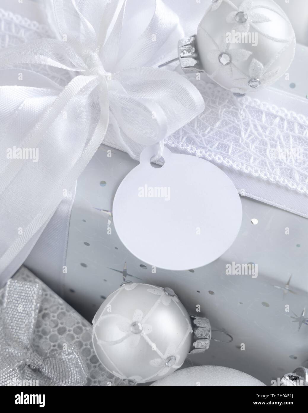 Wrapped present with a white bow and round paper gift tag on a white ...