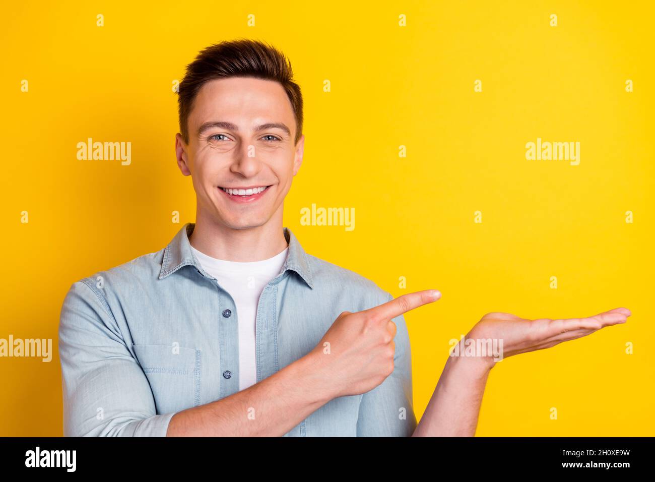 Photo of young cheerful good mood attractive guy advertising product ...