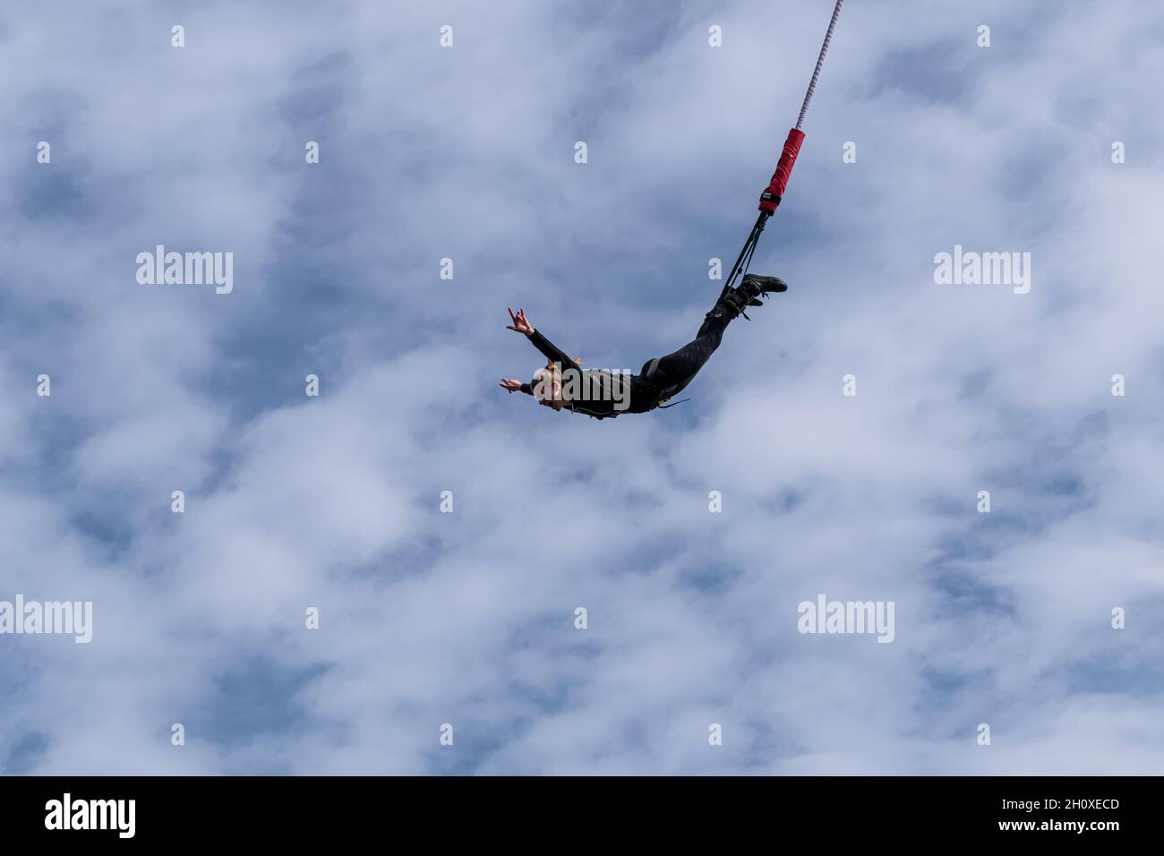 Bungy jumper jumping from a high bridge over the void and down to the ...