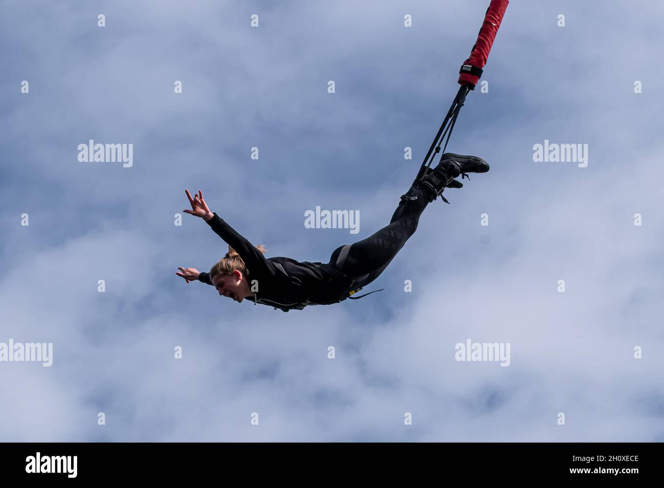 Bungy jumper jumping from a high bridge over the void and down to the ...
